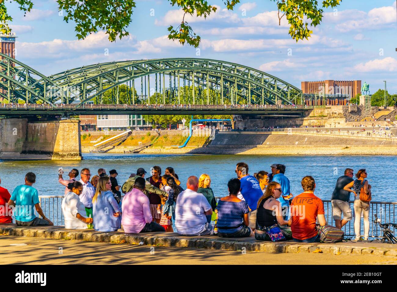 COLOGNE, GERMANY, AUGUST 11, 2018: Group of people siting on riverside ...