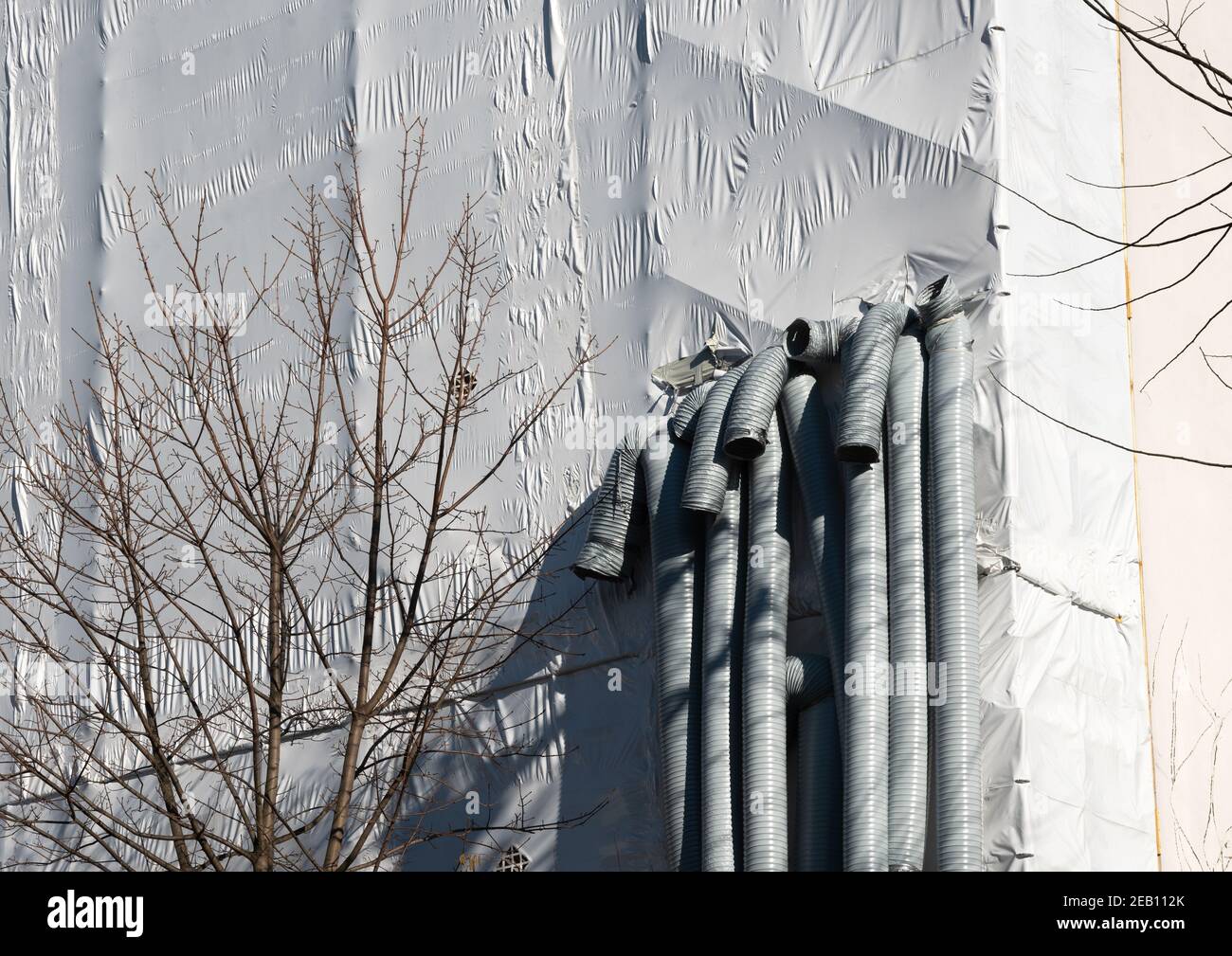Renovation of residential building. House facade covered with plastic ...