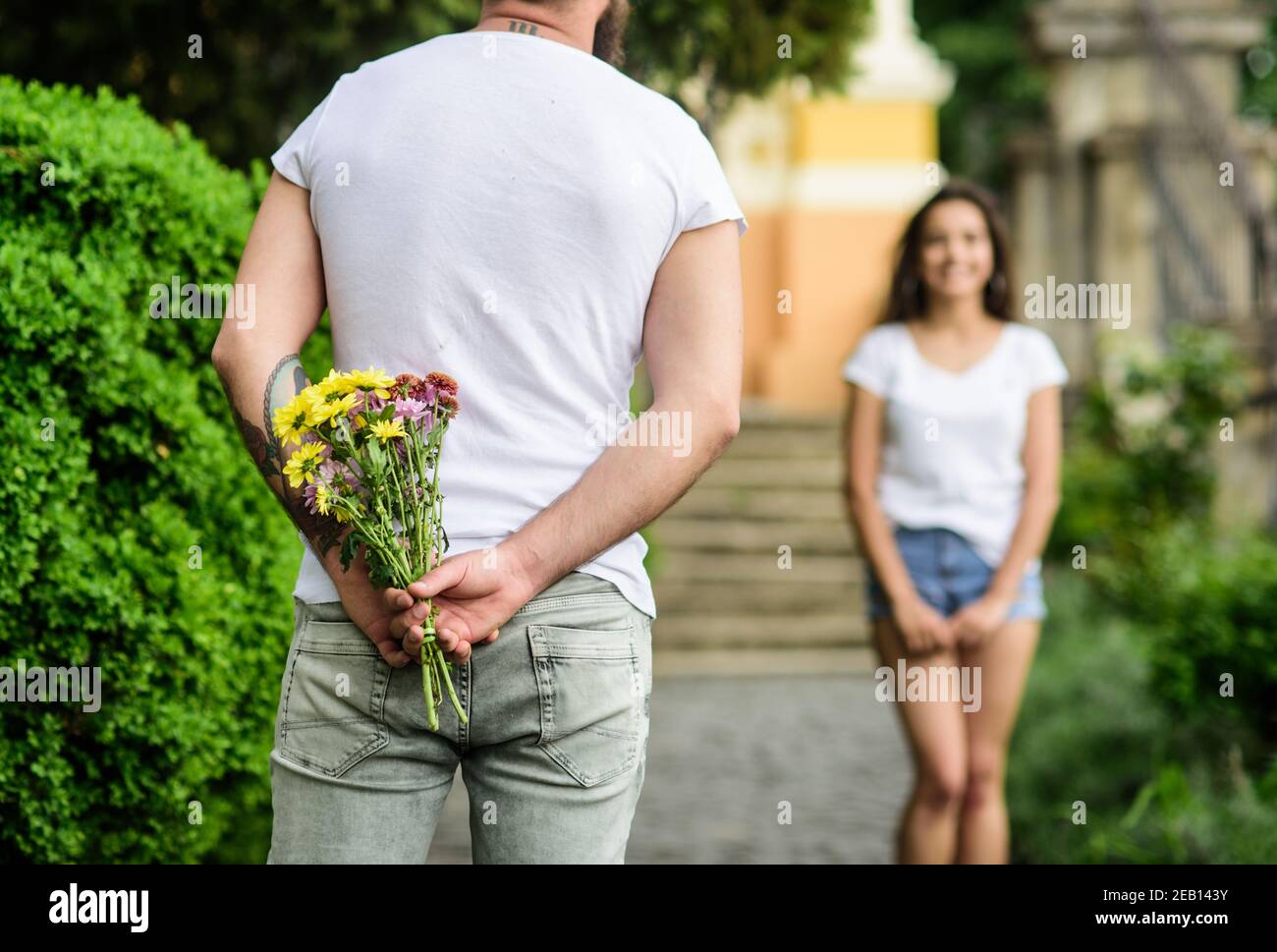 Man hides flower bouquet behind back while waits girl romantic date ...