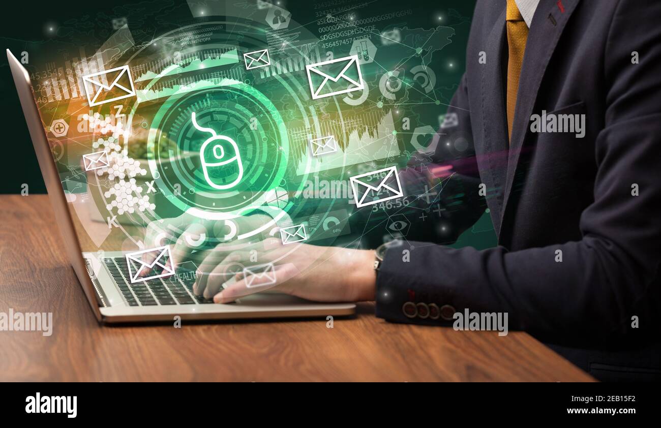 Business hand typing on a modern laptop with mouse icon coming out from ...