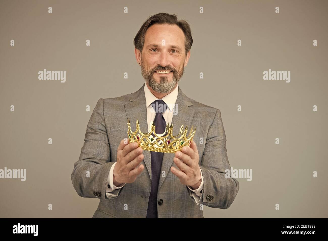 Crown for man who deserves it. Happy businessman hold crown grey ...