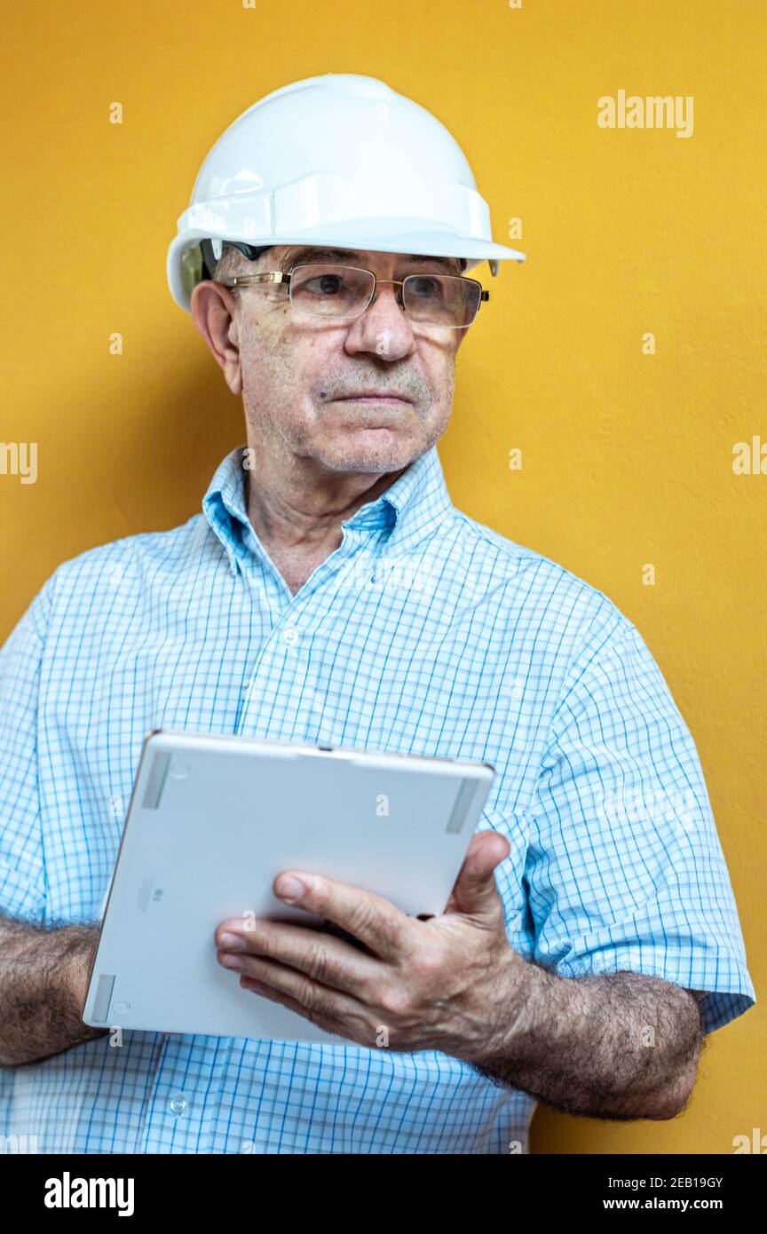 White man with a white engineer helmet holding a tablet Stock Photo - Alamy