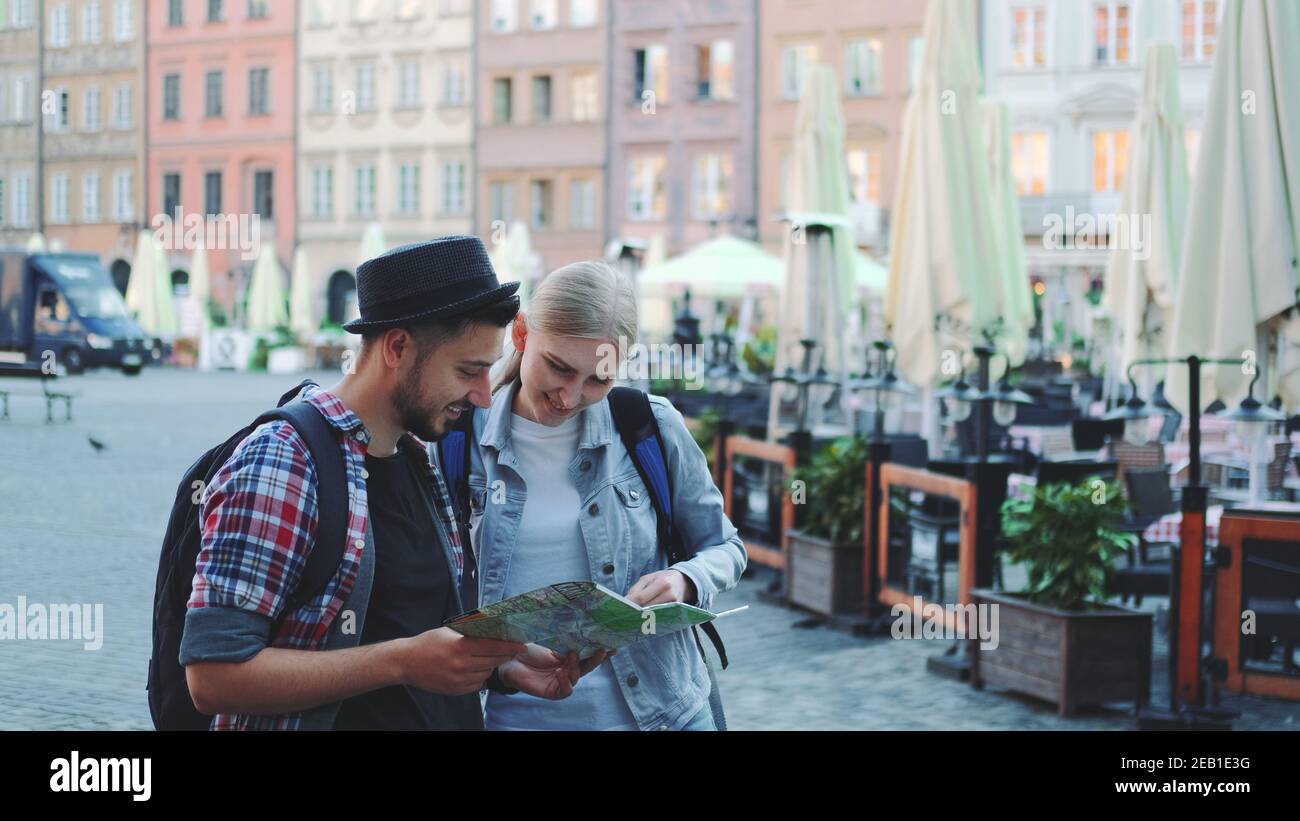 Young man and woman looking on main tourist attractions using map. They ...