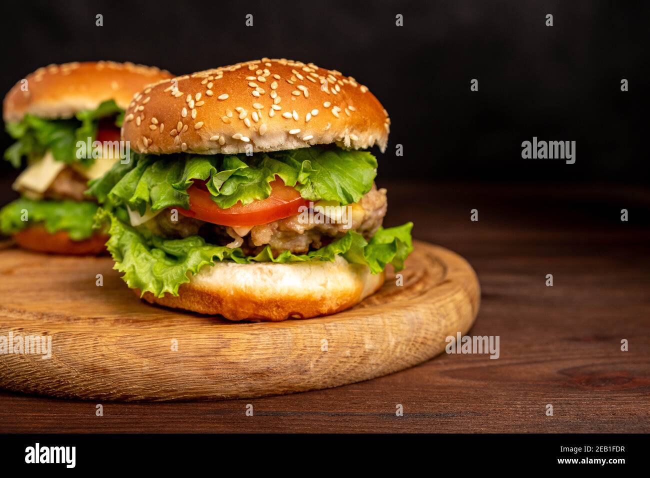 Burger with chicken cutlet, cheese, tomatoes and herbs Stock Photo - Alamy
