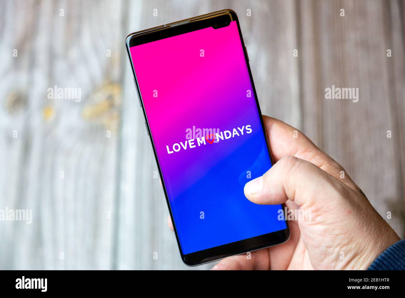 A mobile phone or cell phone being held by a hand with the Reed job ...