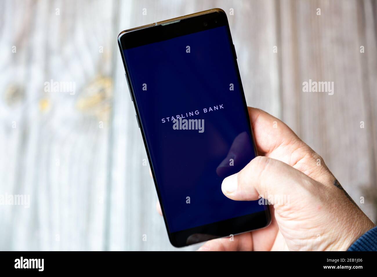 A mobile phone or cell phone being held by a hand with the Starling ...