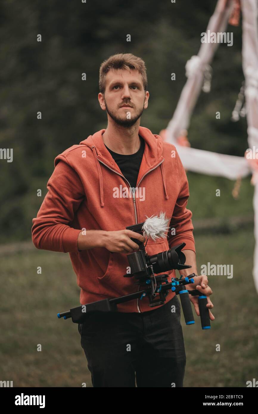 Shallow focus of a professional male photographer holding a camera and ...