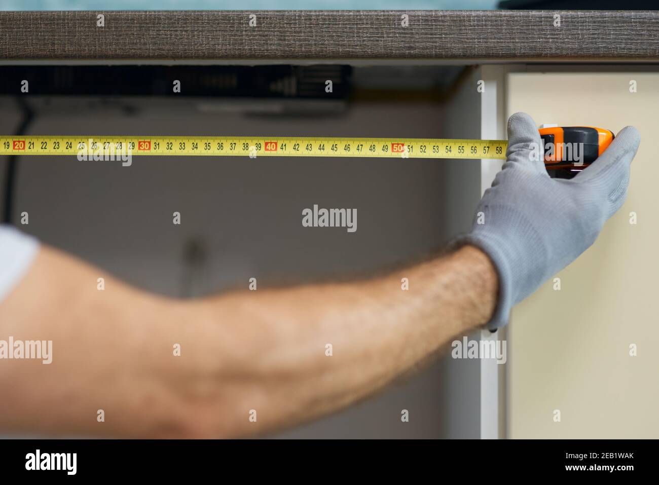 Close up of hand of young repairman, professional plumber using measure ...