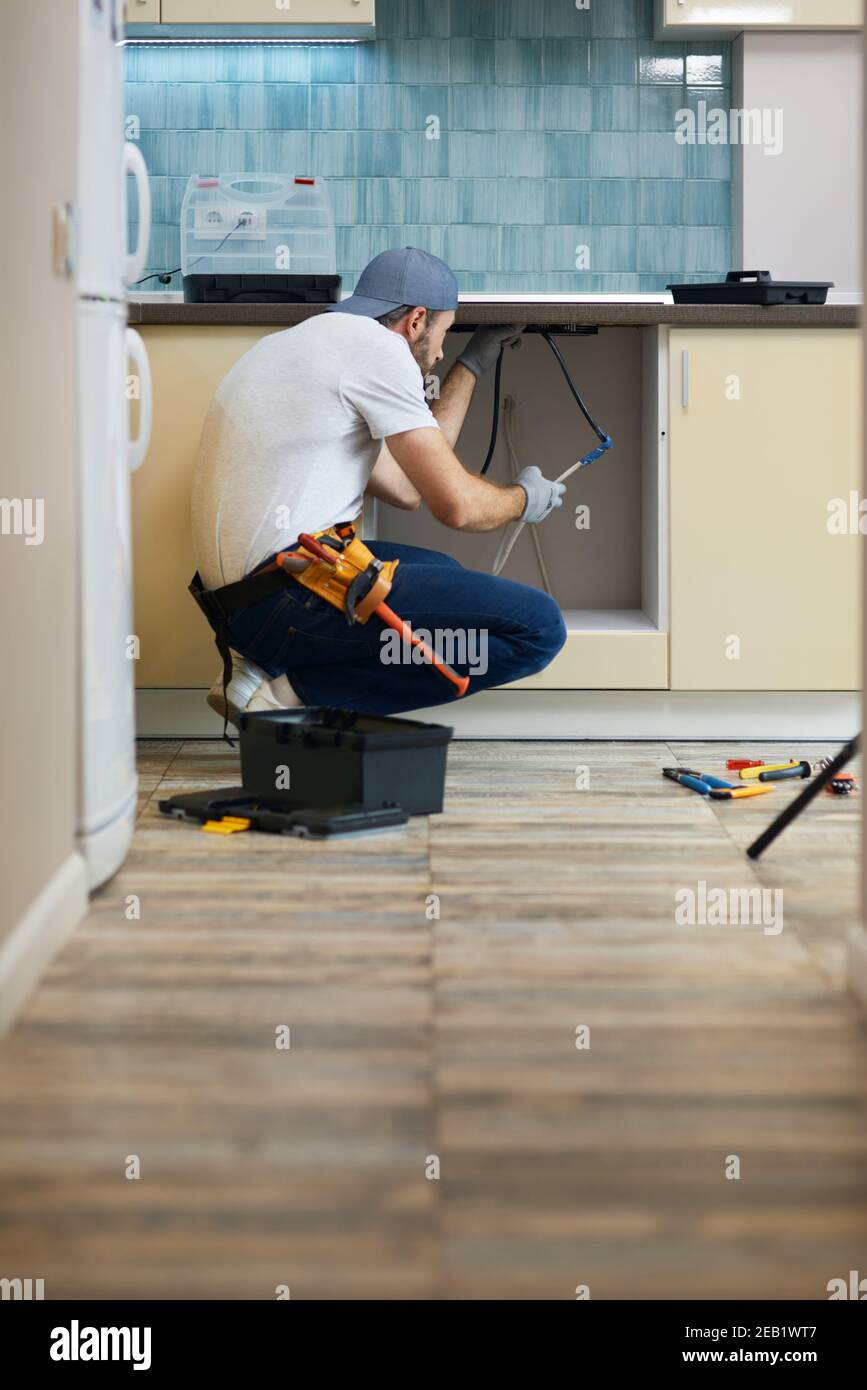 Handyman in uniform fixing pipes hi-res stock photography and images ...