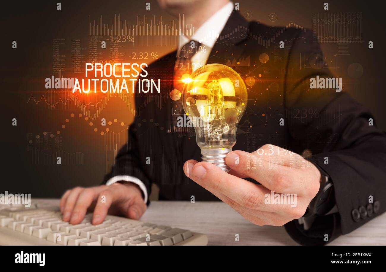 Businessman holding lightbulb with PROCESS AUTOMATION inscription ...
