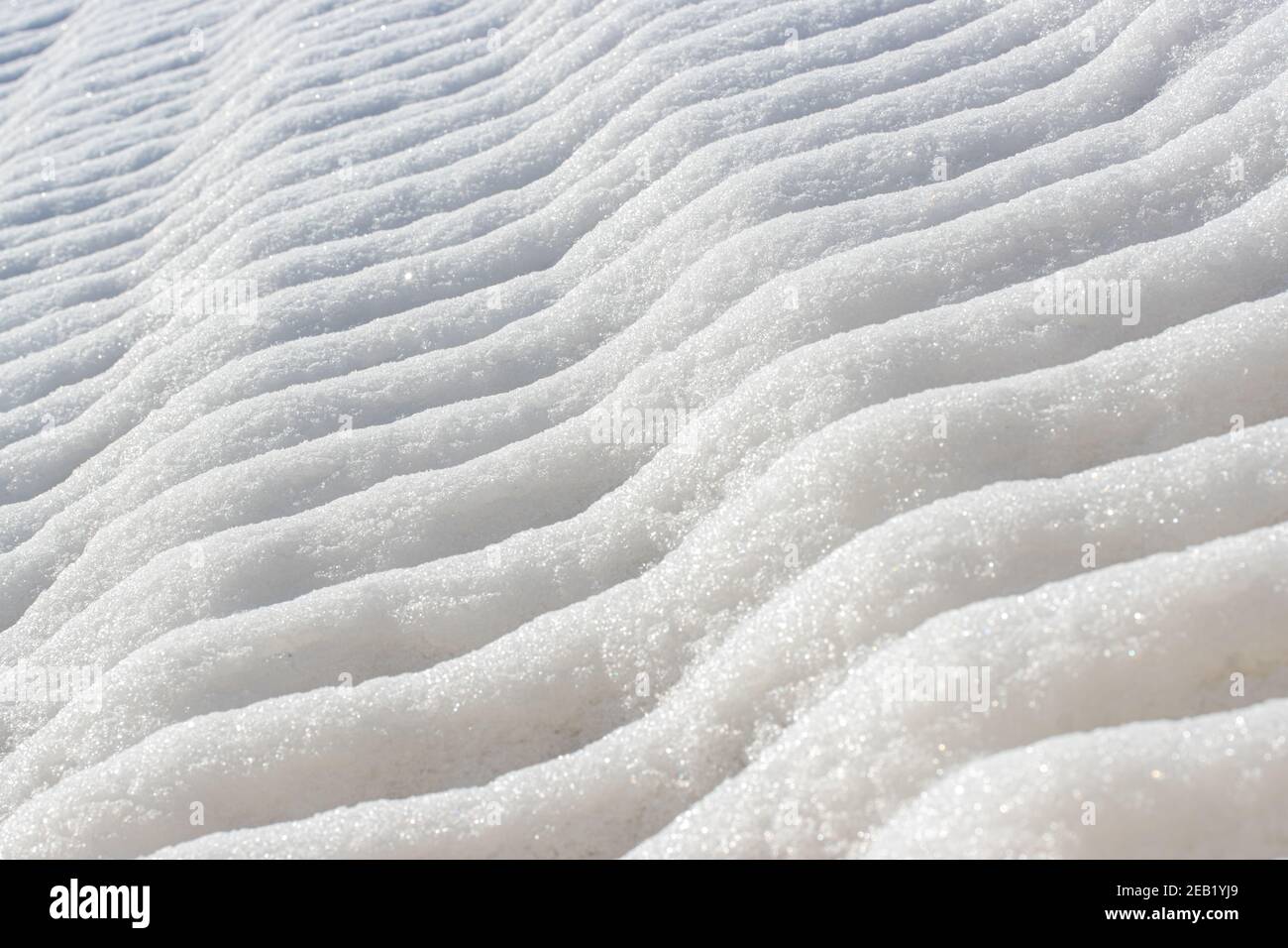 Snowy waves on the roof of the house. The roof tiles are covered with ...