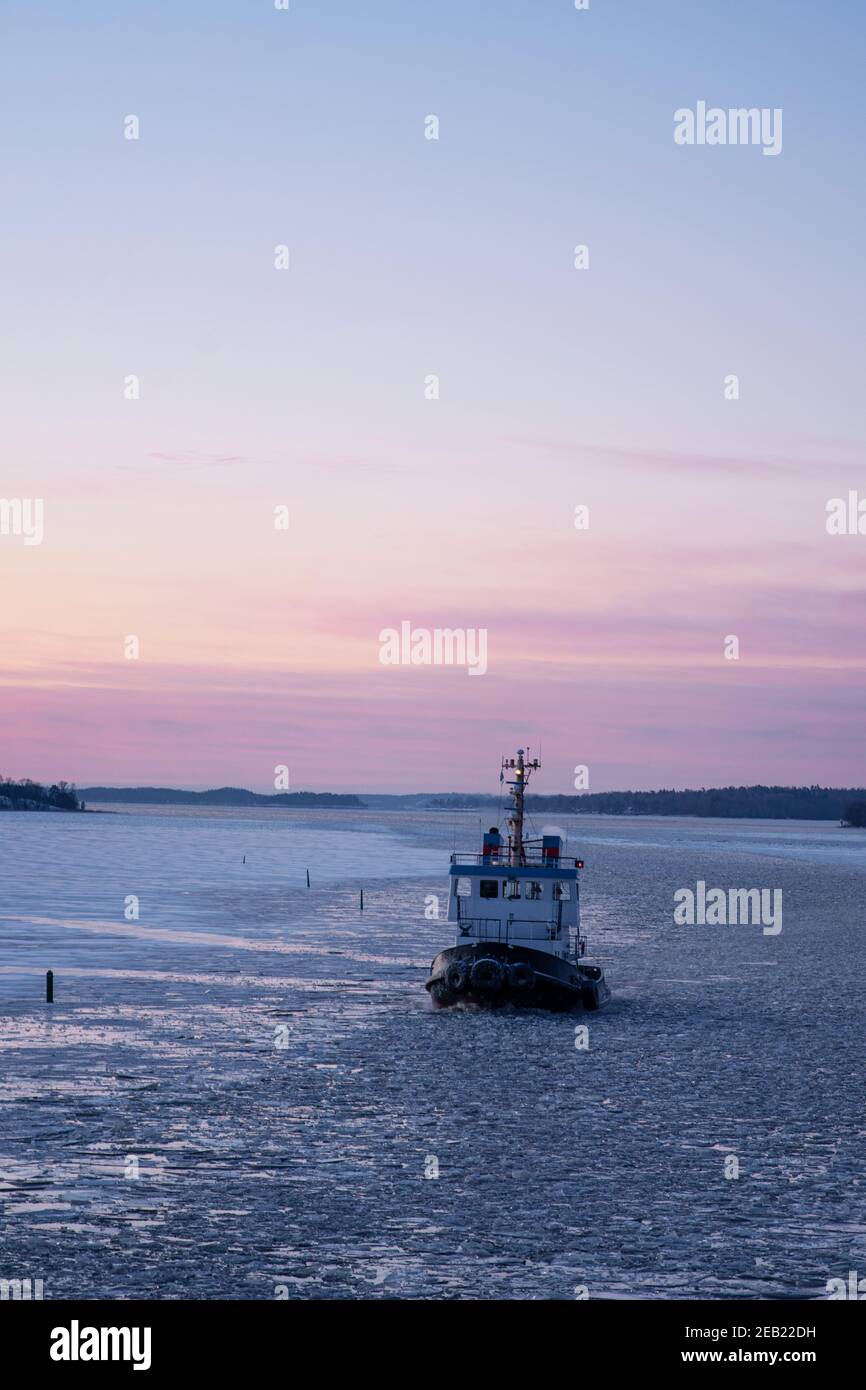 Beautiful sunset over frozen water. Icebreaker ship breaking through ...