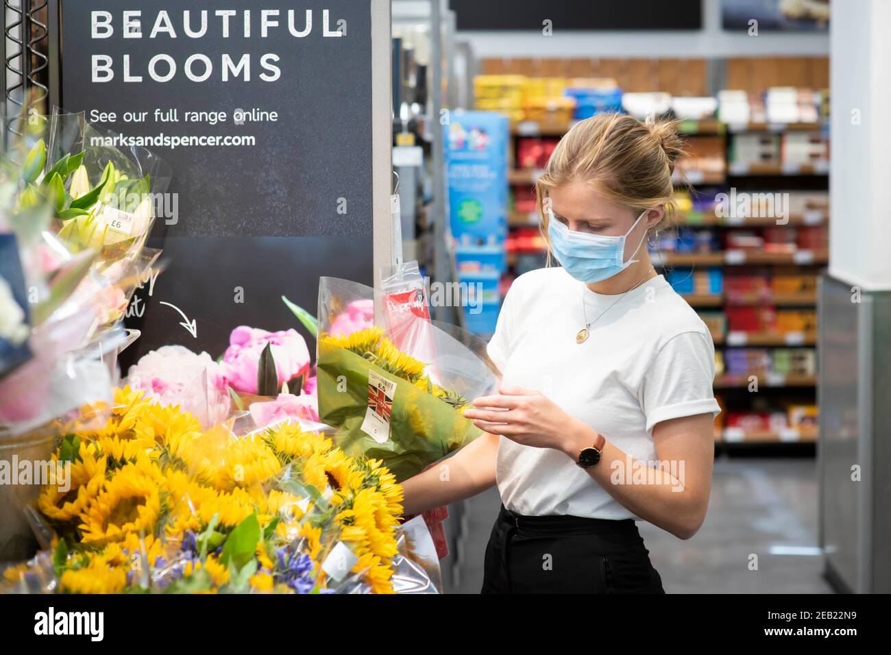 A woman shops wearing a face covering, as face masks become compulsory ...