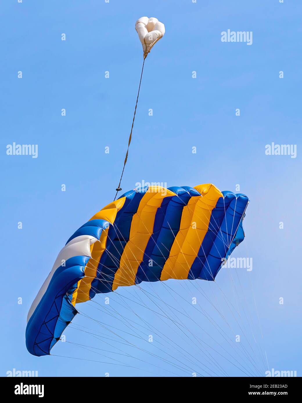 Blue and yellow skydiving parachute against a clear blue sky Stock ...