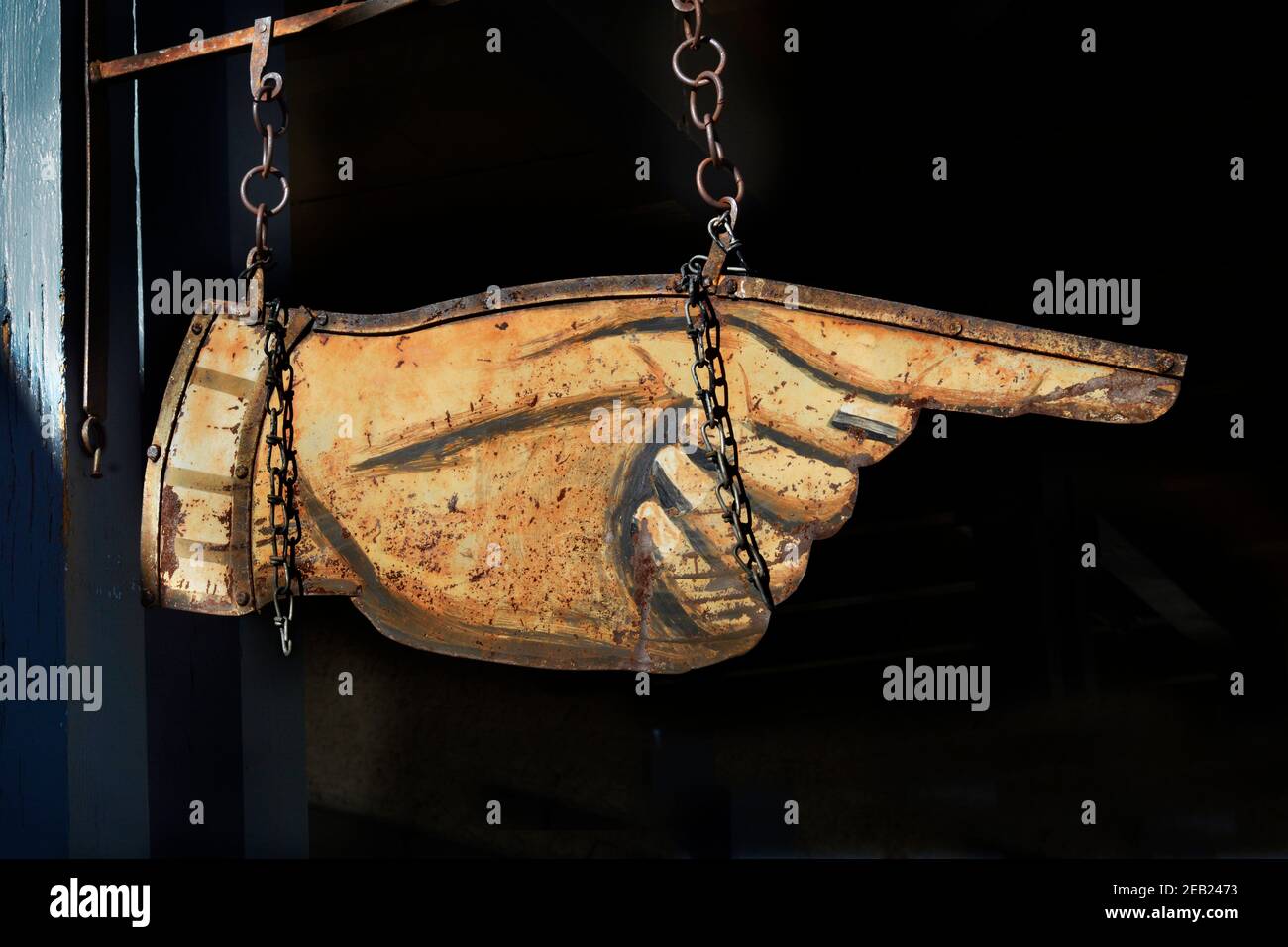 A vintage sign in the shape of a hand with a pointing finger hanging ...