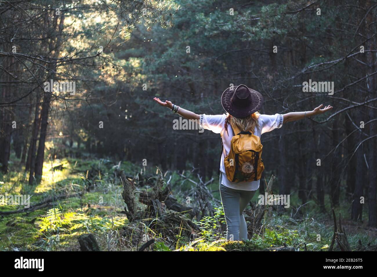 Happy tourist with arms outstretched standing at forest. Enjoyment of ...