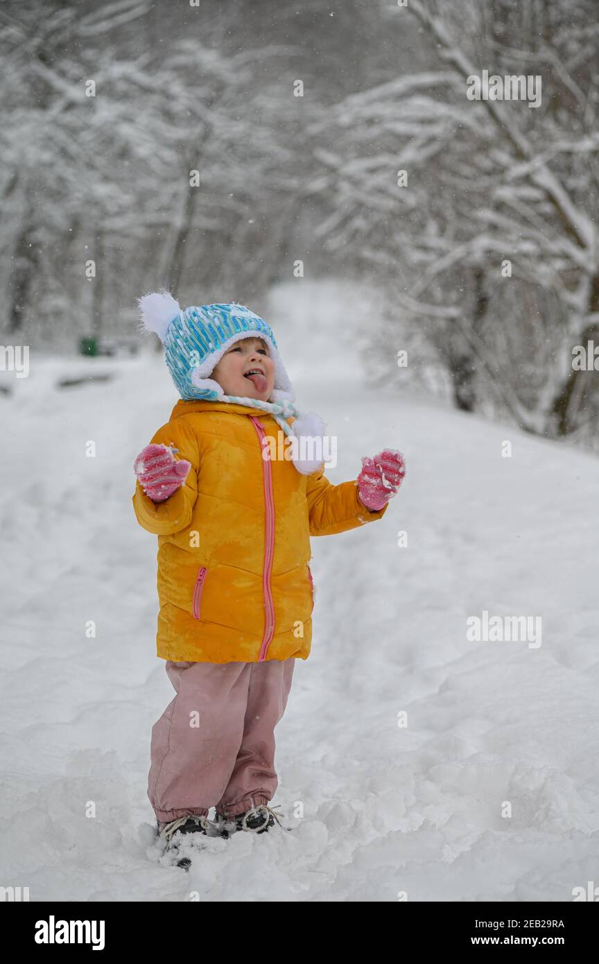 little girl catching snowflakes on tongue Stock Photo - Alamy