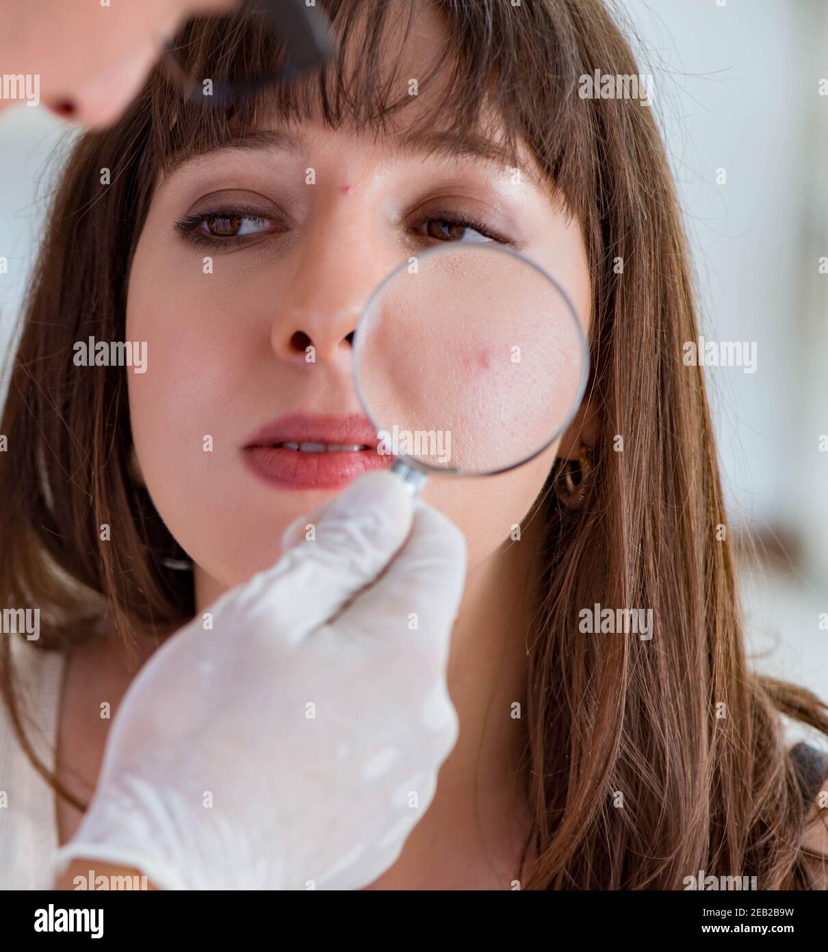 The doctor examining the skin of female patient Stock Photo - Alamy