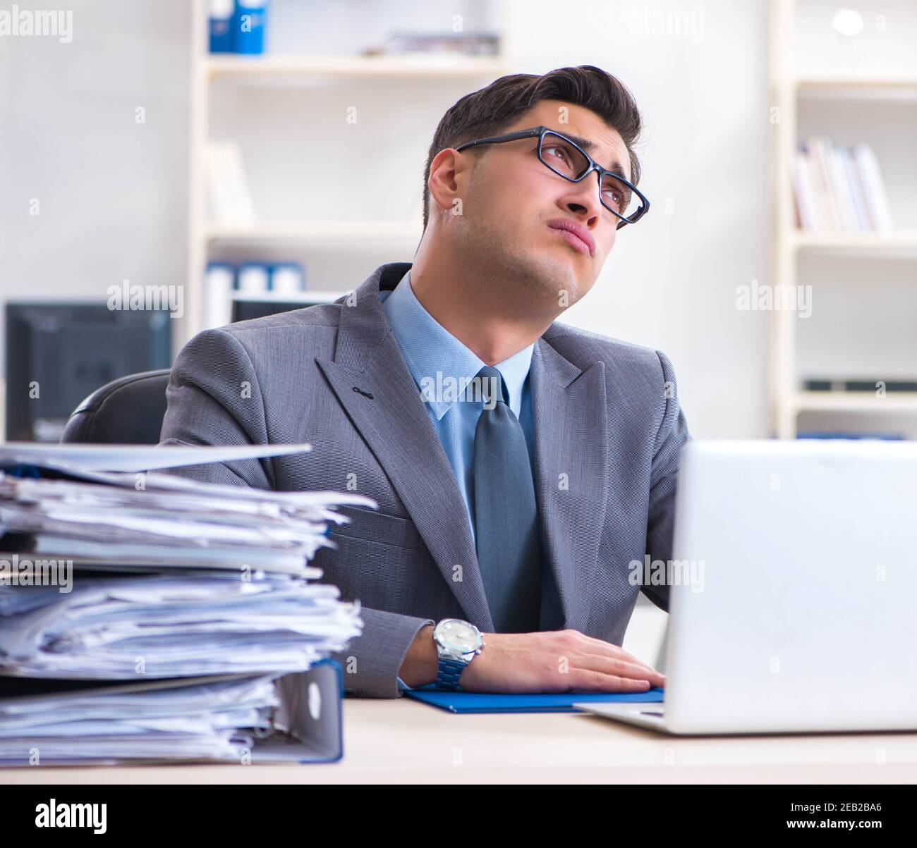 The overloaded with work employee under paperwork burden Stock Photo ...