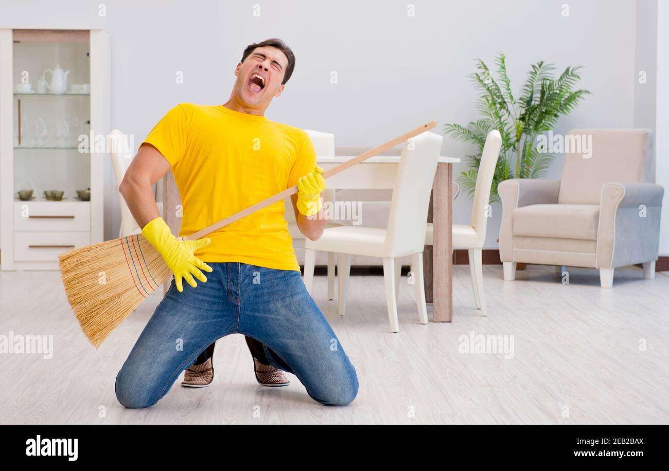 The funny man playing virtual guitar with broom Stock Photo - Alamy