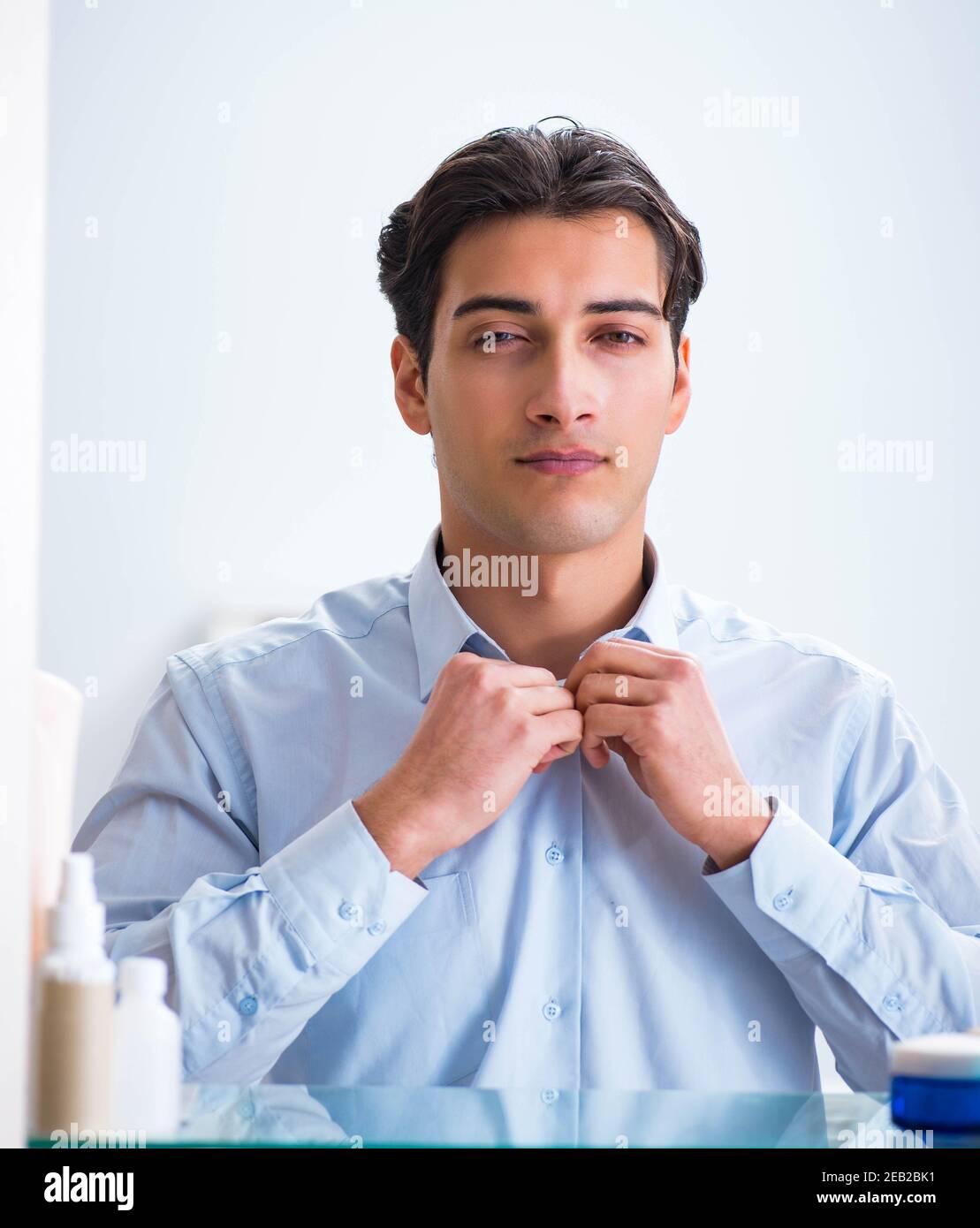 The man is getting dressed up for work in bathroom Stock Photo - Alamy