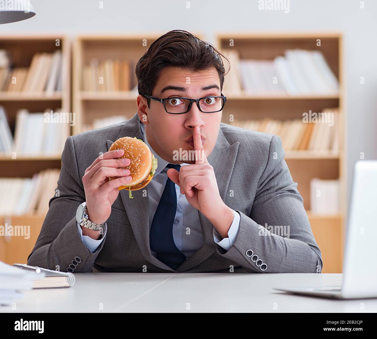 The hungry funny businessman eating junk food sandwich Stock Photo - Alamy