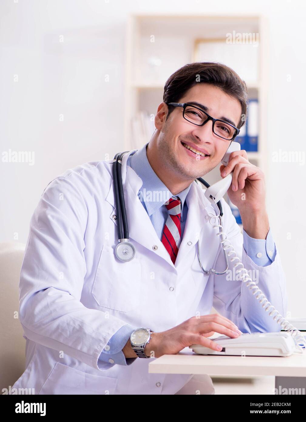 The young handsome doctor working in hospital room Stock Photo - Alamy