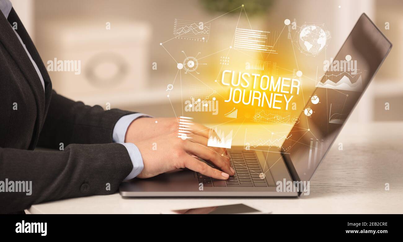 Side view of a business person working on laptop with CUSTOMER JOURNEY ...