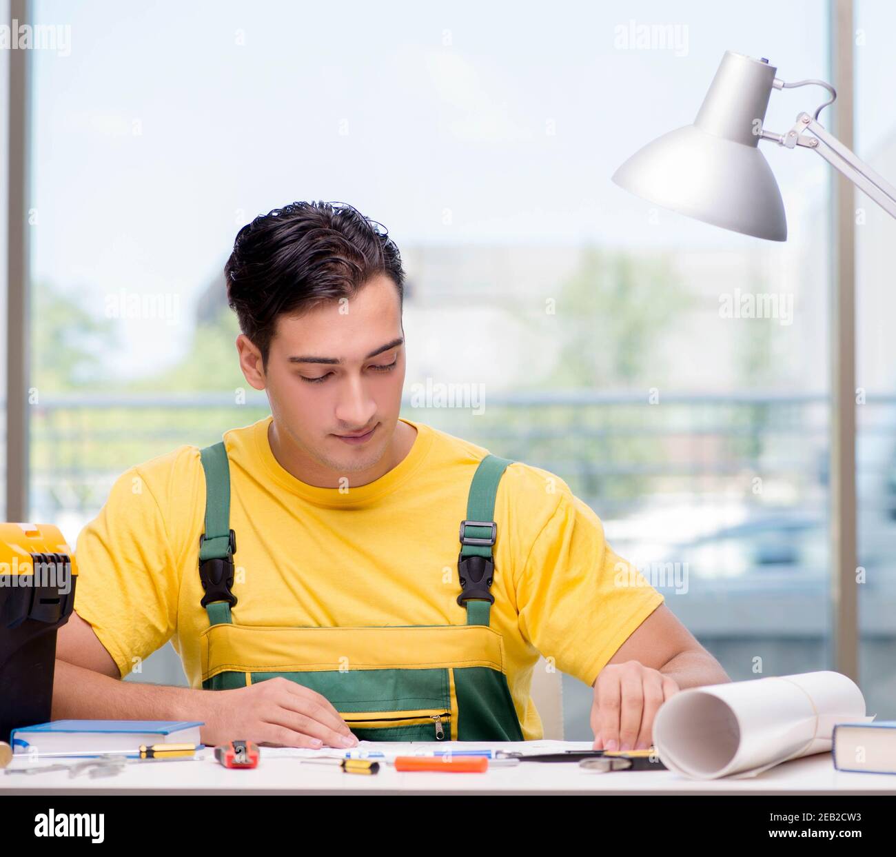 The construction worker sitting at the desk Stock Photo - Alamy
