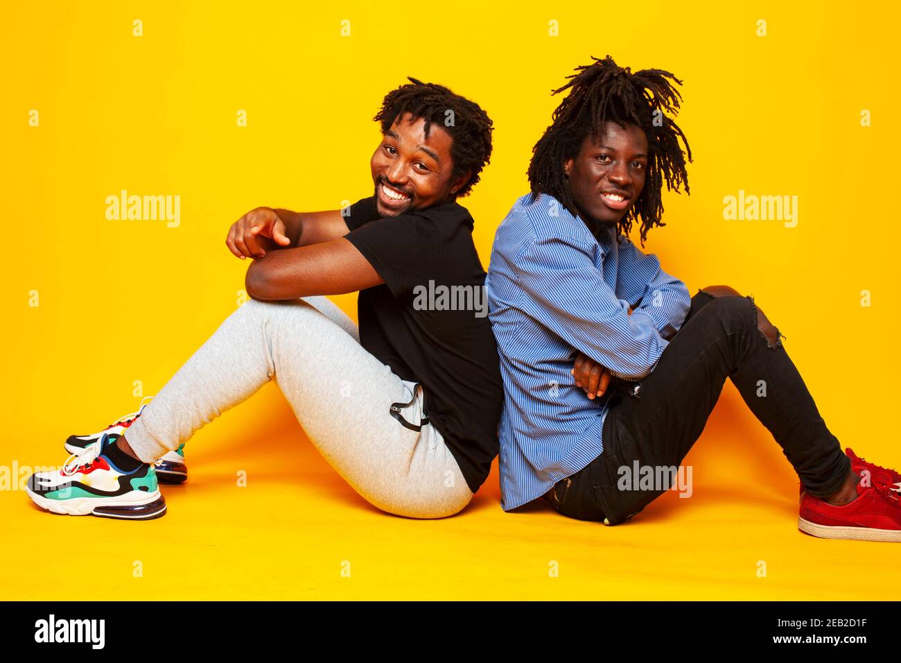 two african american guys posing cheerful together on yellow background ...