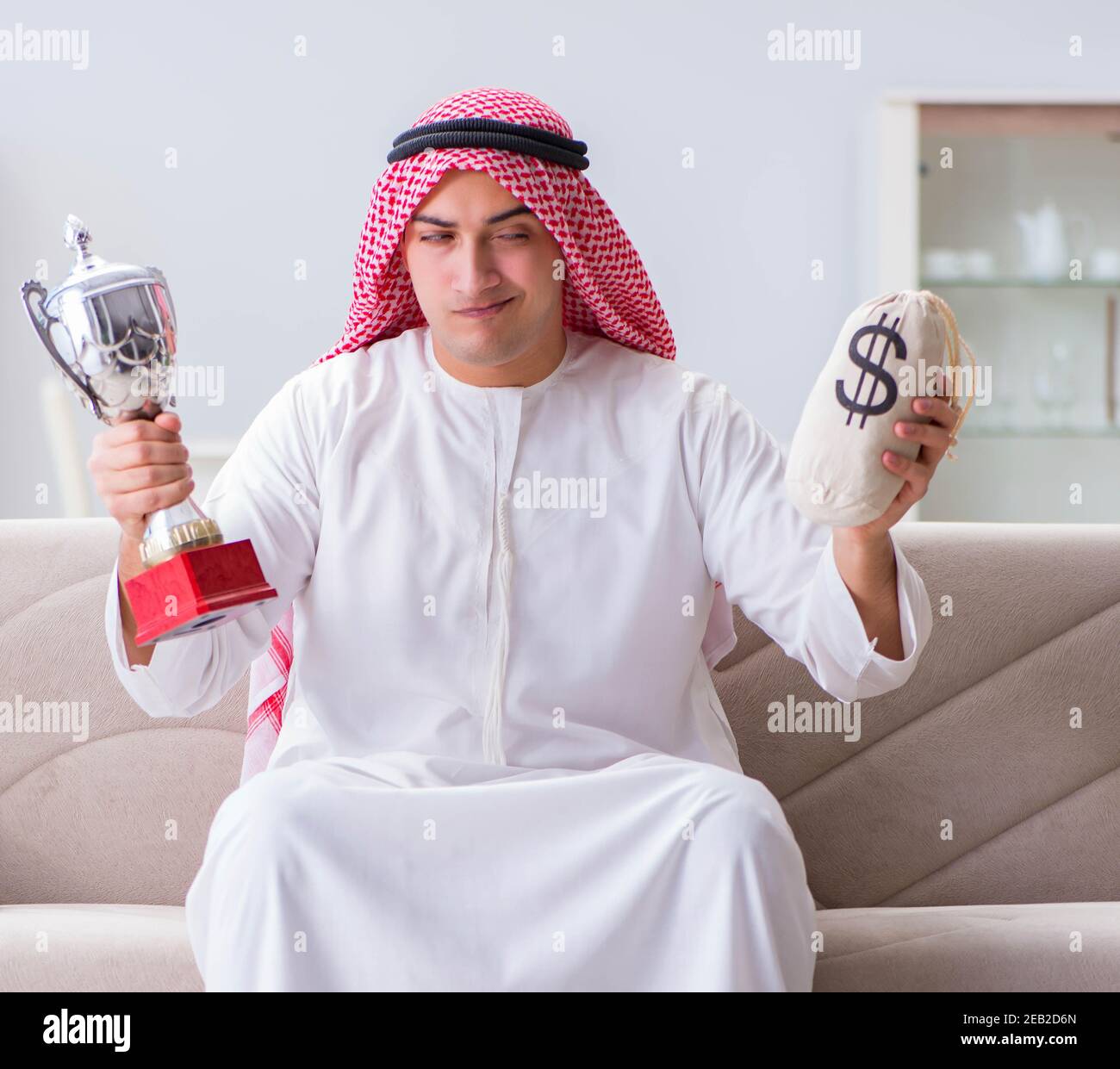 The arab man with prize and money on sofa Stock Photo - Alamy