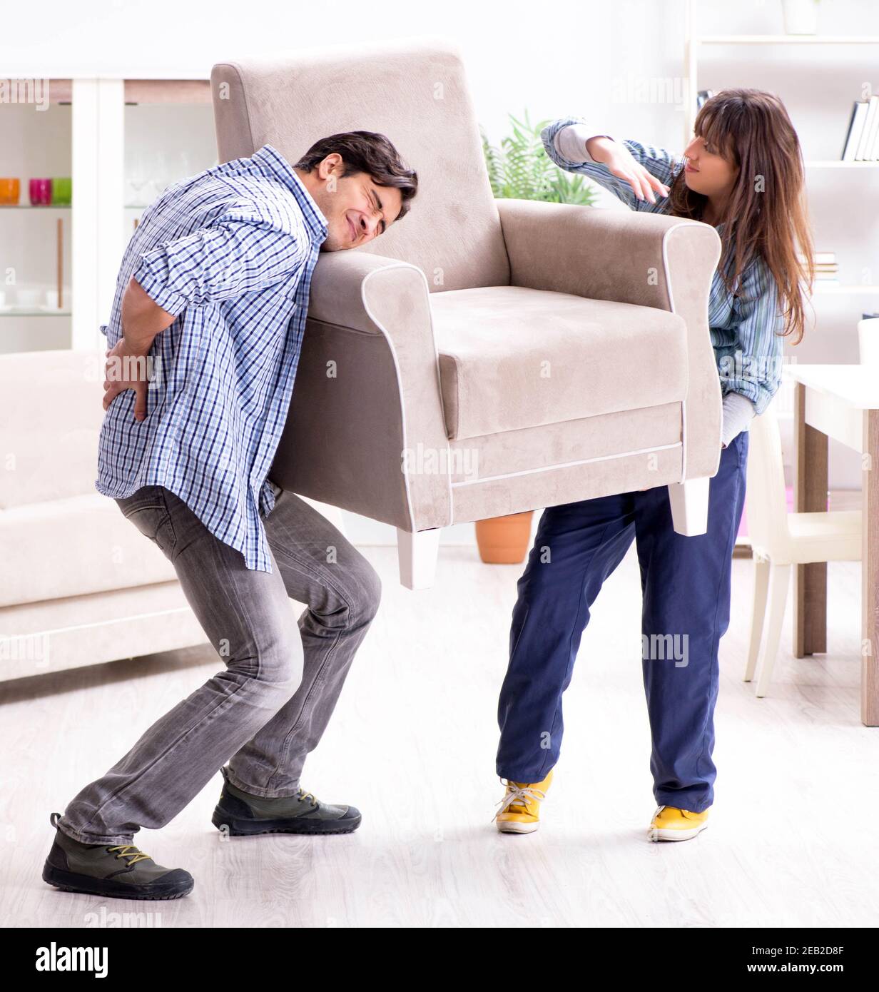 The man moving armchair in the living room Stock Photo - Alamy
