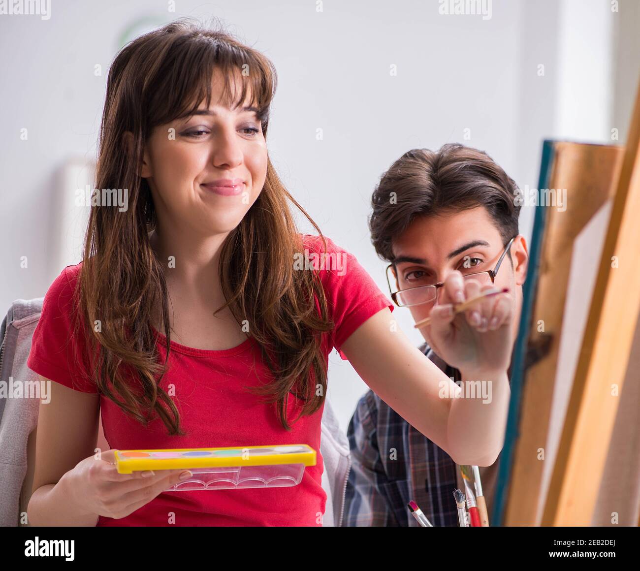 The artist coaching student in painting class in studio Stock Photo - Alamy