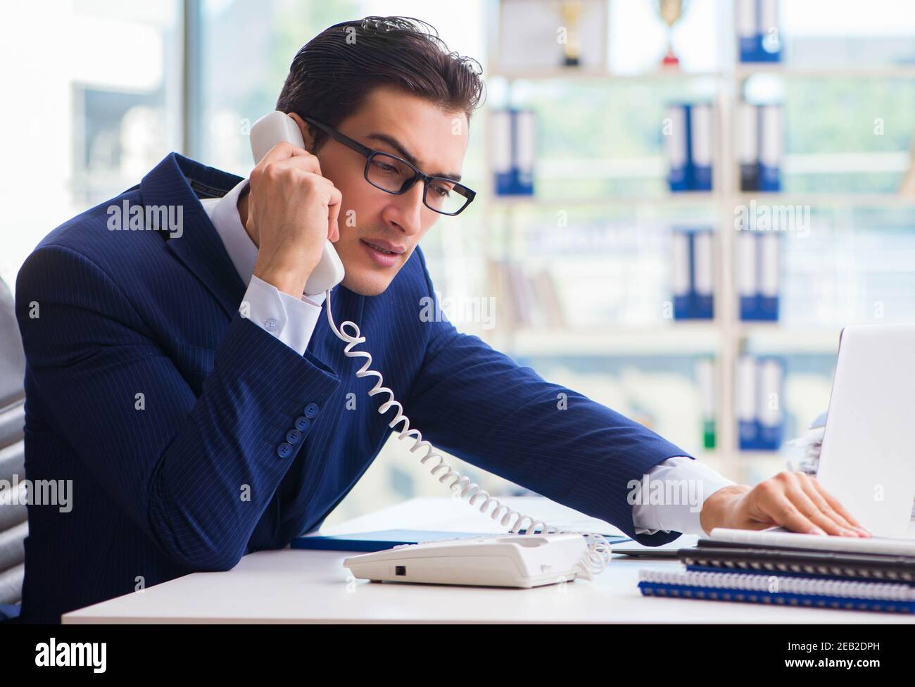 The businessman employee talking on the office phone Stock Photo - Alamy