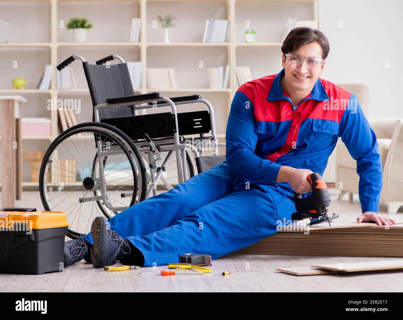 The disabled man laying floor laminate in office Stock Photo - Alamy