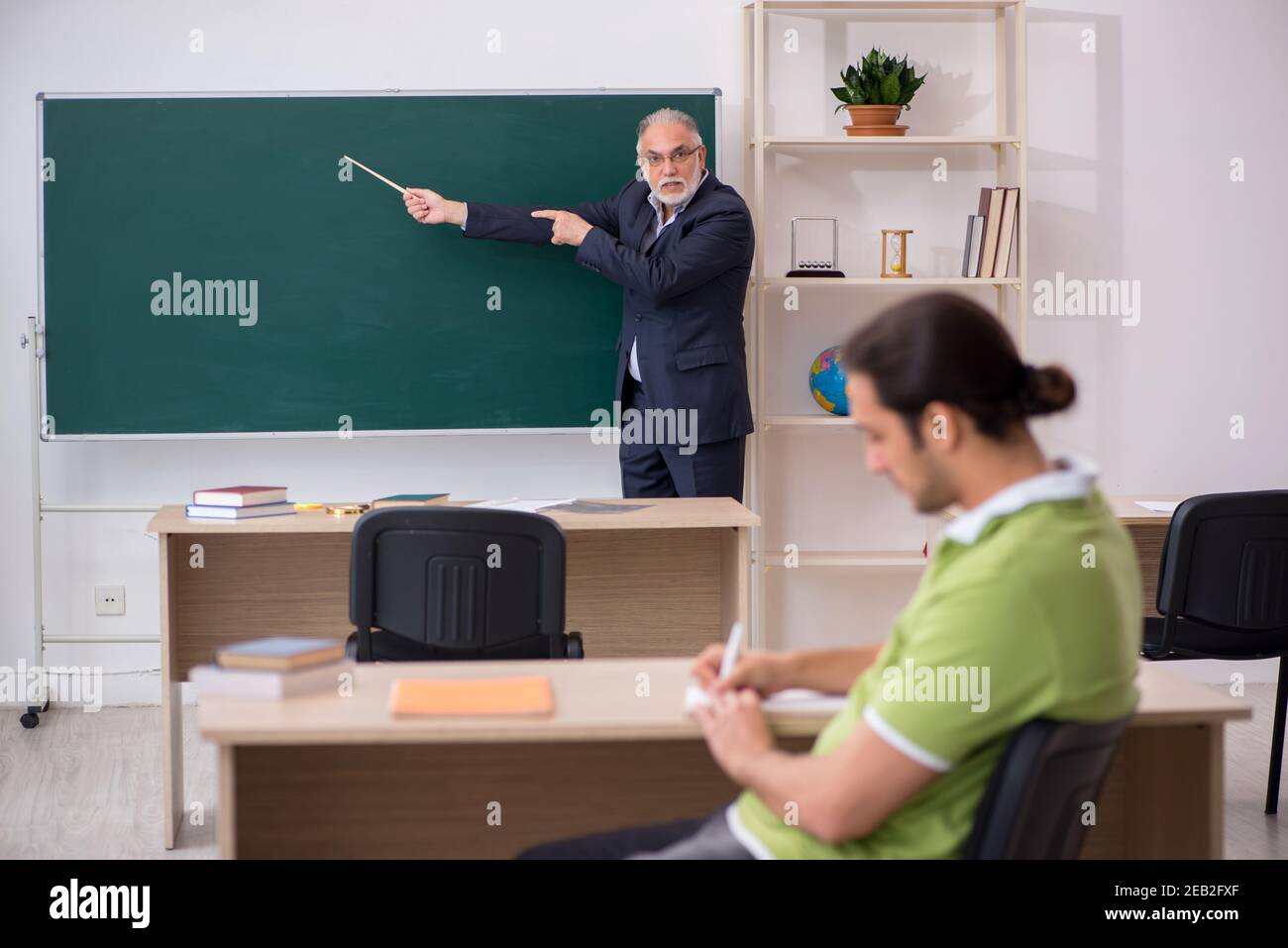Aged male teacher and young male student in the classroom Stock Photo ...