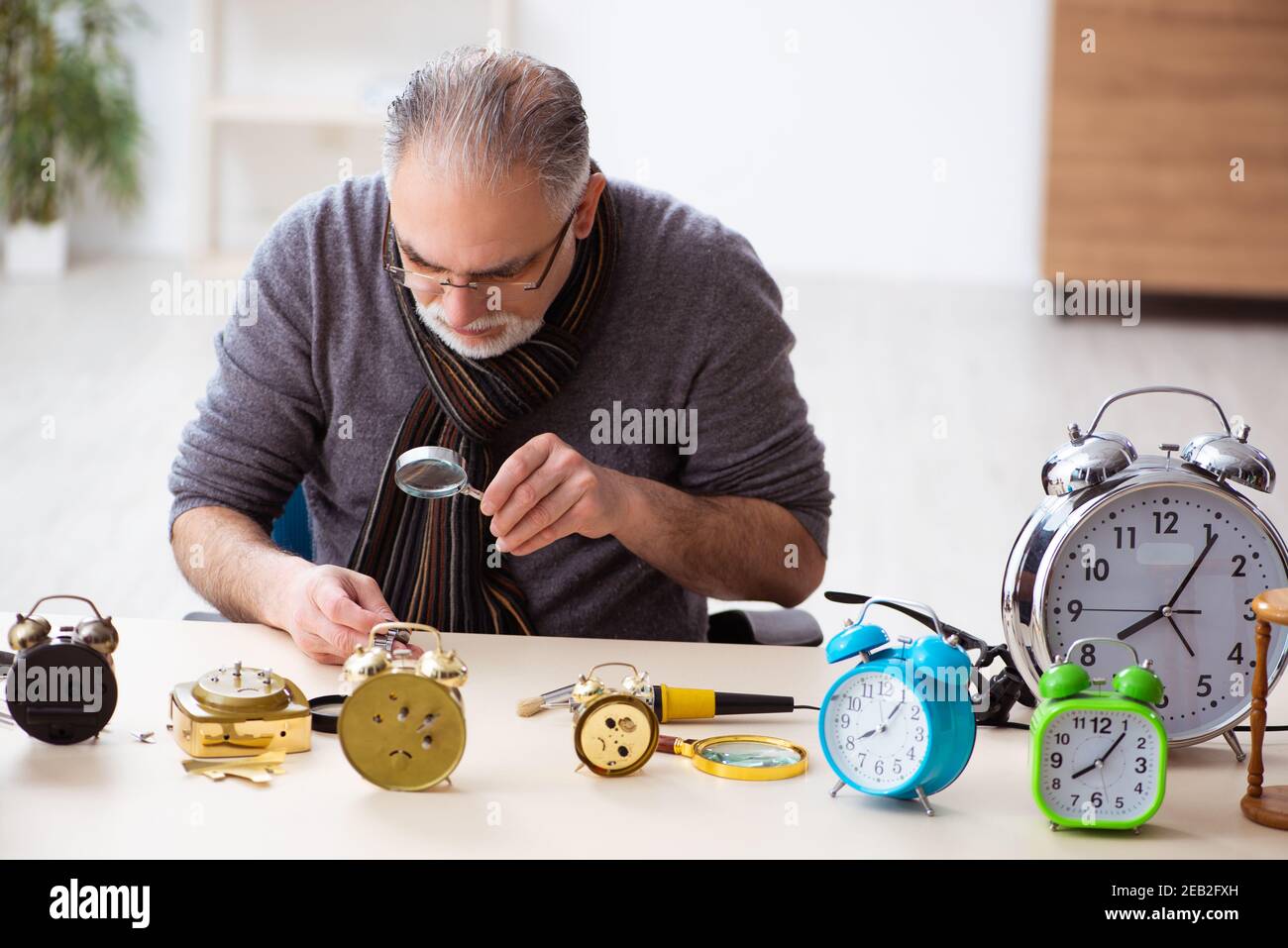 Old watchmaker working in the workshop Stock Photo - Alamy