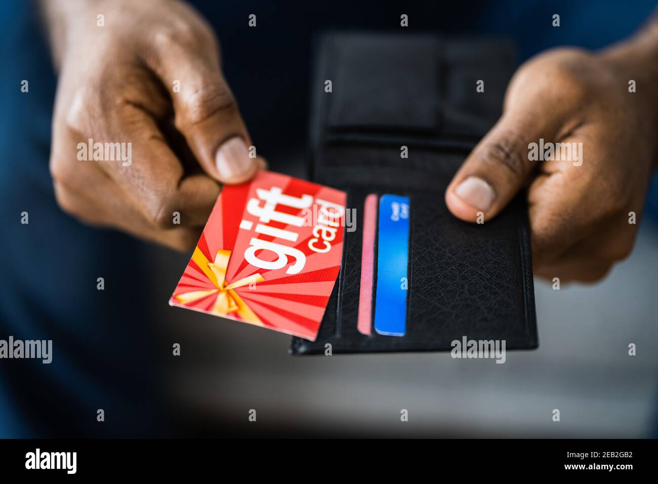 African Hand Holding Gift Card Shopping Voucher Stock Photo - Alamy
