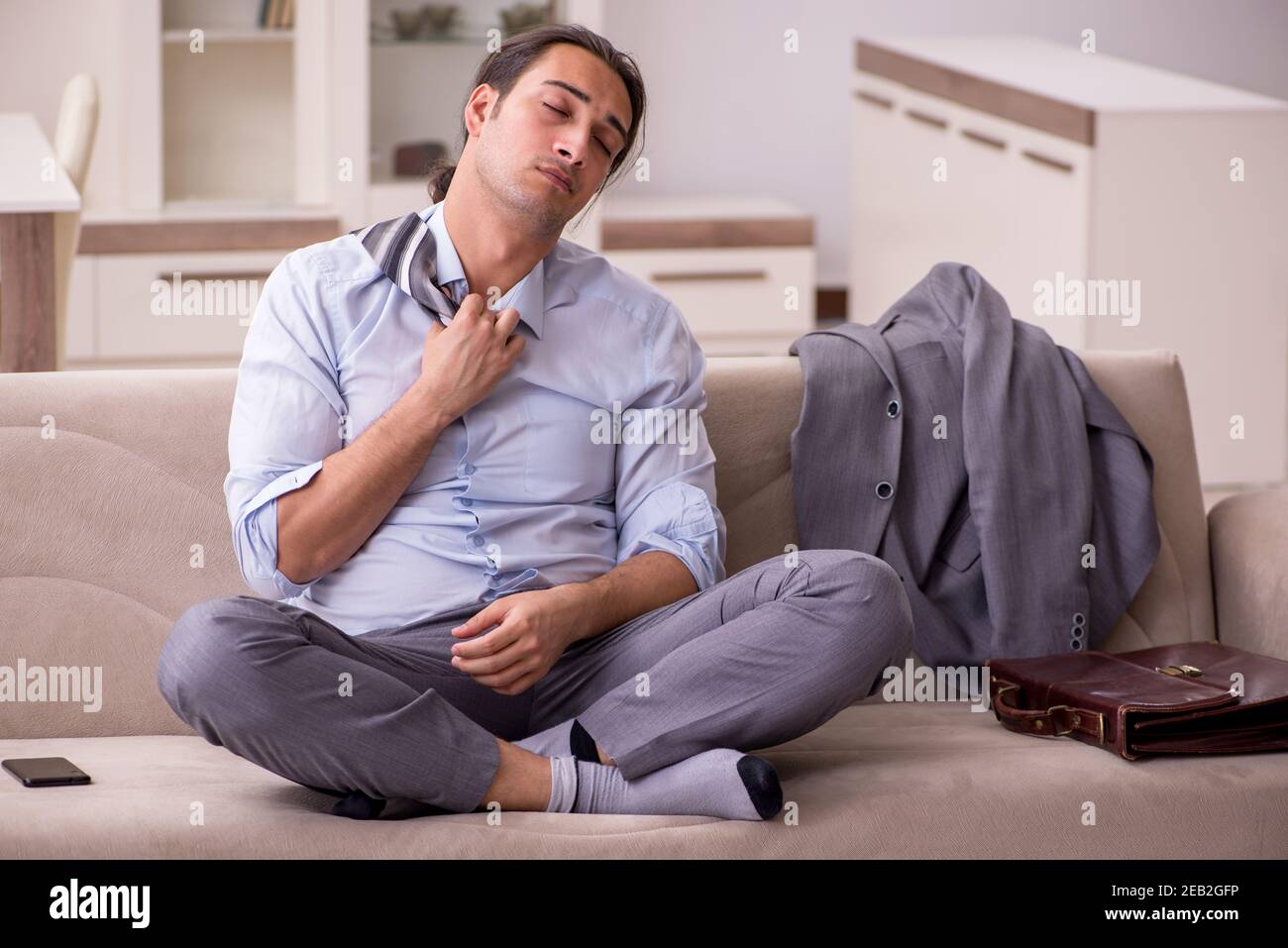 Tired businessman coming home after working day Stock Photo - Alamy