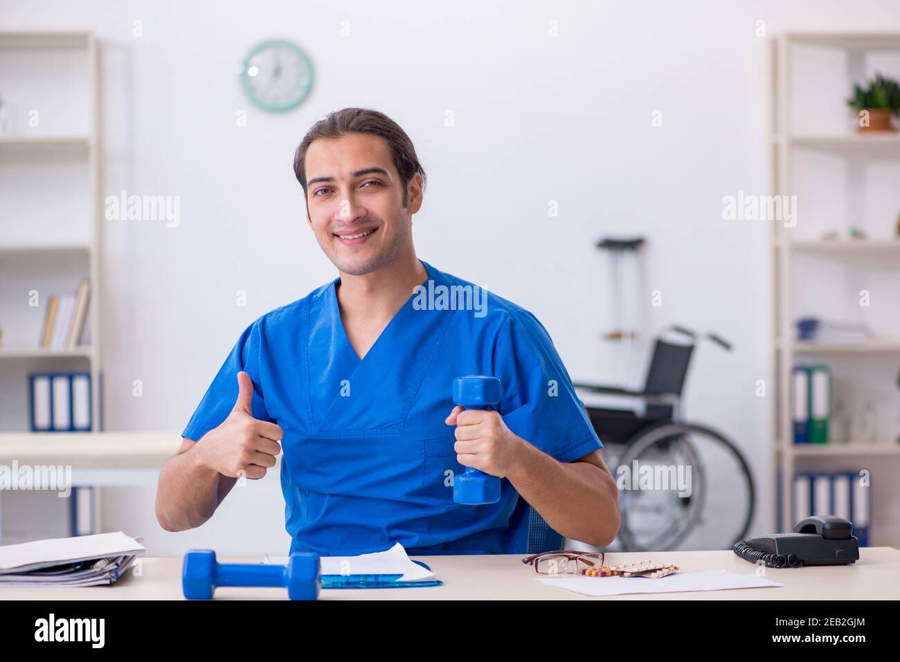Young doctor physiotherapist doing sport exercises Stock Photo - Alamy