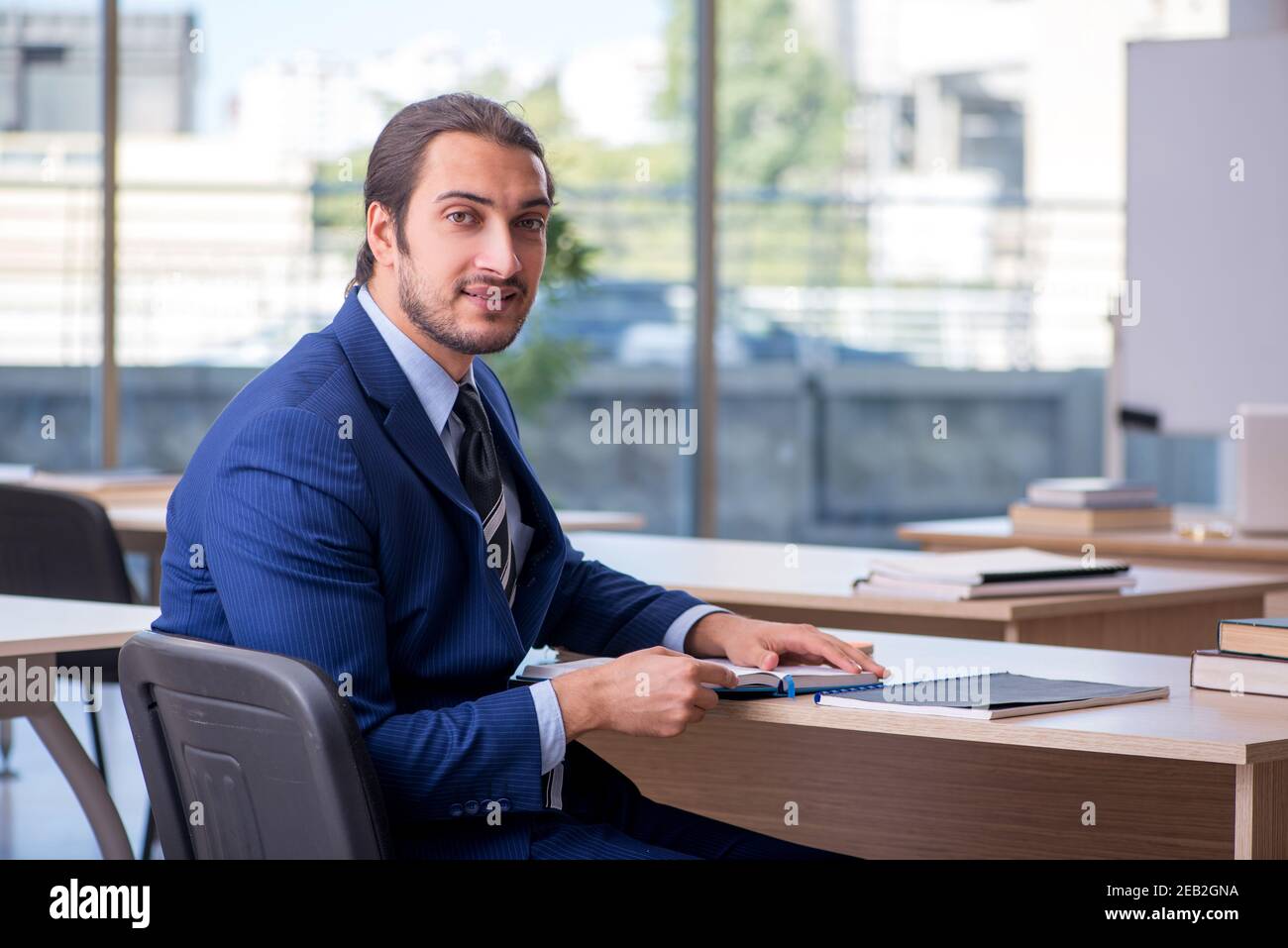 Young teacher in suit in the classroom Stock Photo - Alamy