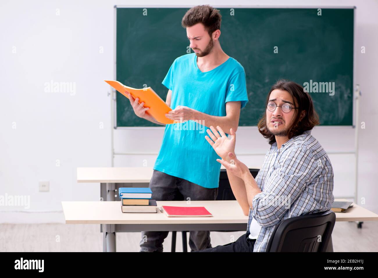 Male pupils in bullying concept in the classroom Stock Photo - Alamy