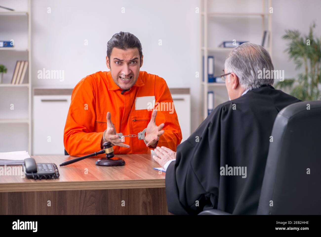 Old judge meeting with young captive in courthouse Stock Photo - Alamy