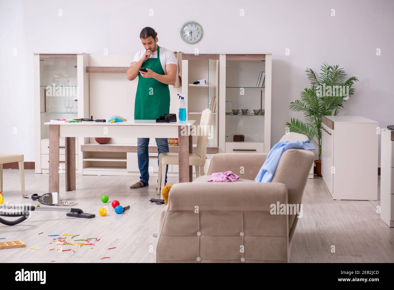Young contractor cleaning the flat after kids' party Stock Photo - Alamy