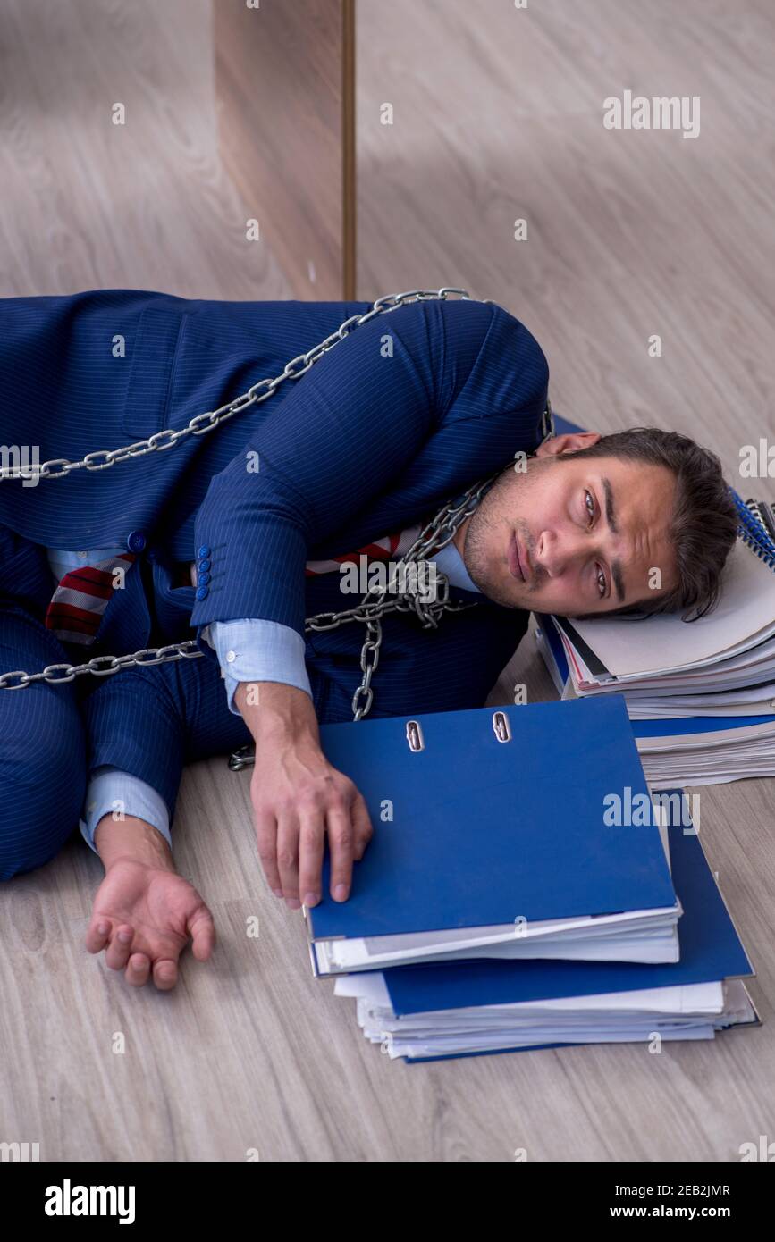 Chained employee unhappy with excessive work in the office Stock Photo ...