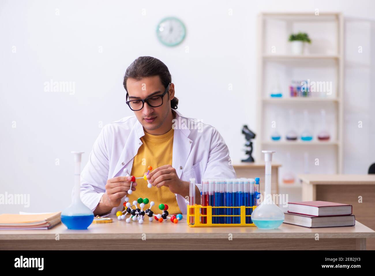 Young chemist studying molecular model in the classroom Stock Photo - Alamy