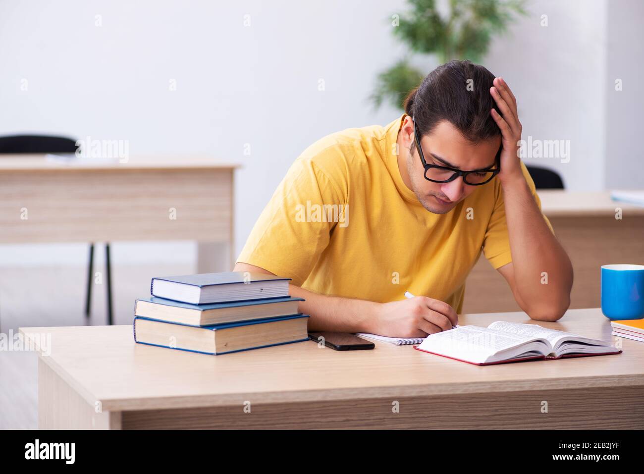 Young student taking notes during exam preparation Stock Photo - Alamy