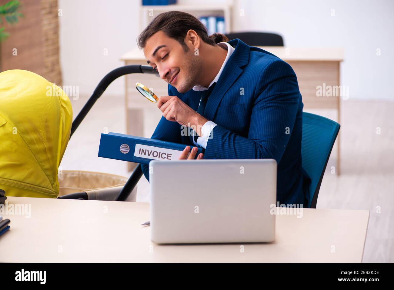 Young employee looking after kid at workplace Stock Photo - Alamy