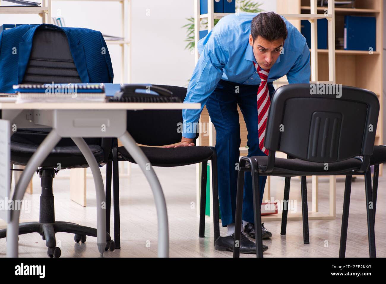 Young businessman doing sport exercises at workplace Stock Photo - Alamy