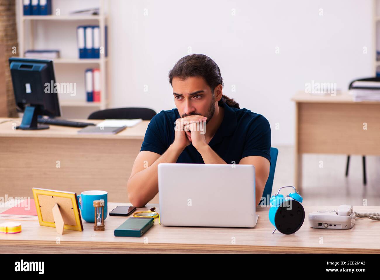 Young employee working at workplace Stock Photo - Alamy